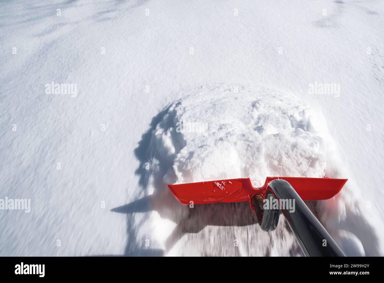 A red snow shovel pushing snow with motion blur Stock Photo - Alamy