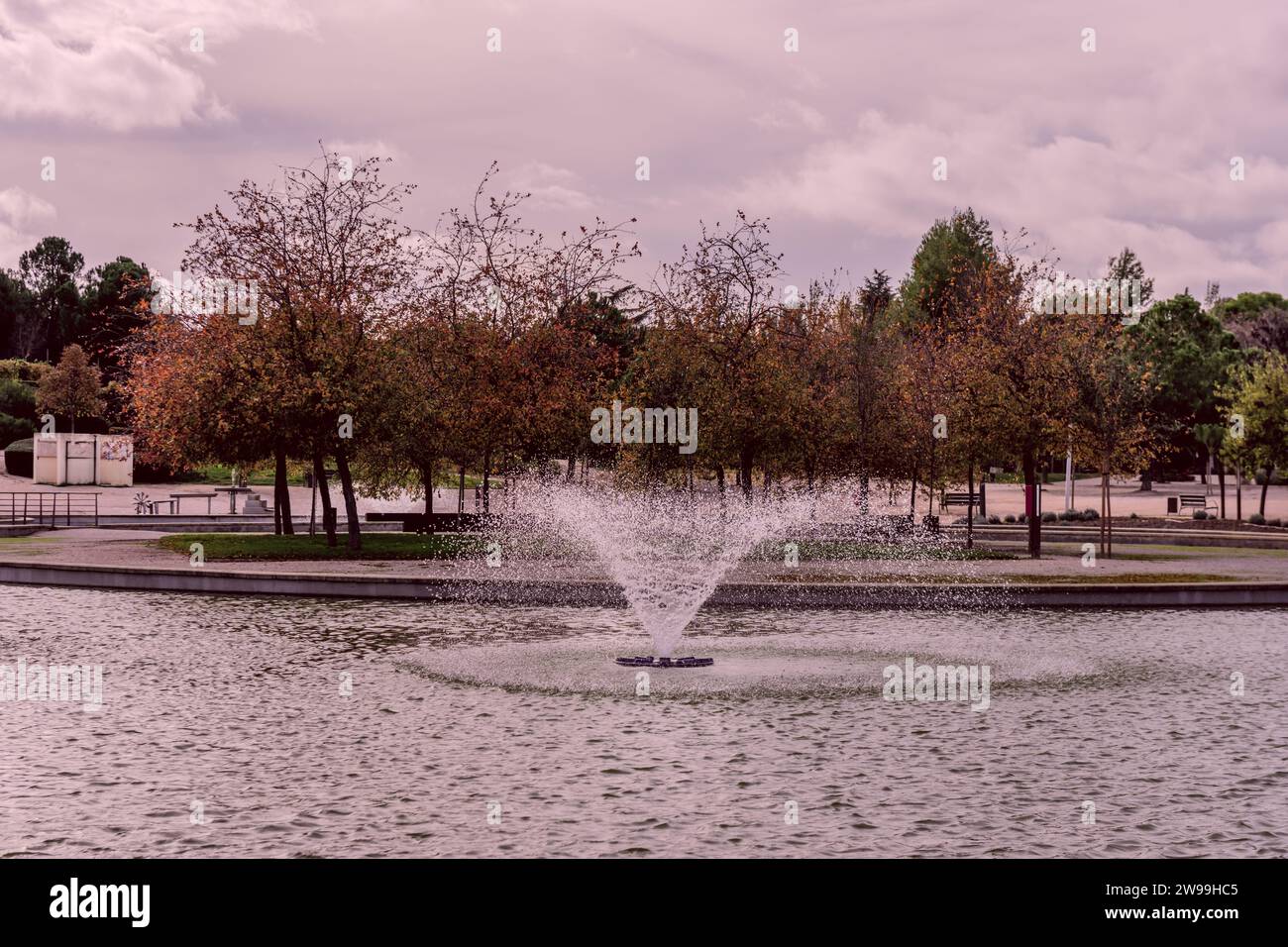 A fountain in the middle of an artificial lagoon releasing a circular ...
