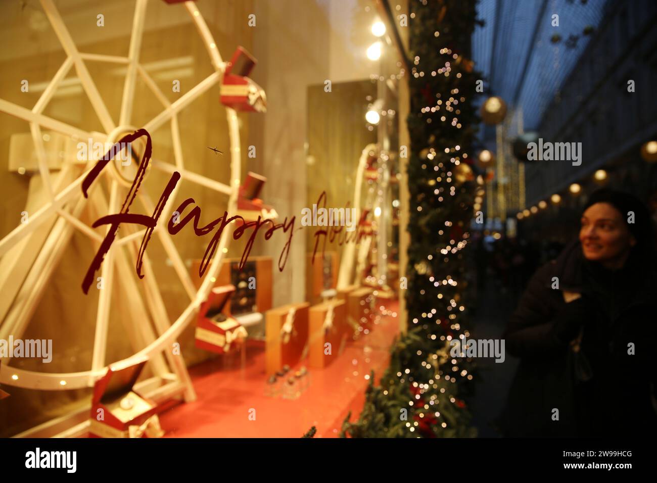 Brussels, Belgium. 25th Dec, 2023. A woman looks at holiday window ...