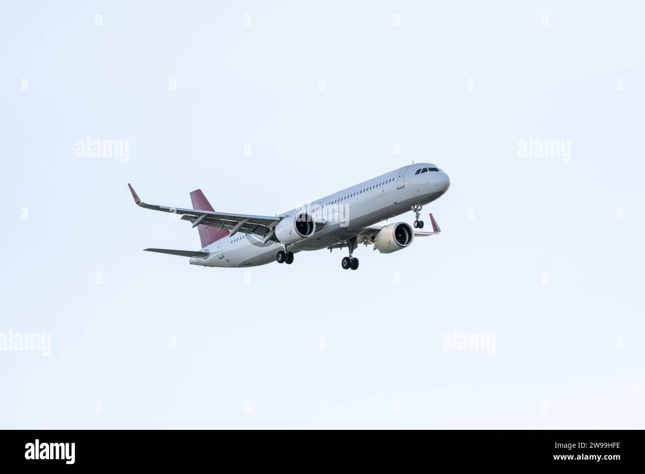 an airplane lowering the landing gear to approach an airport runway ...
