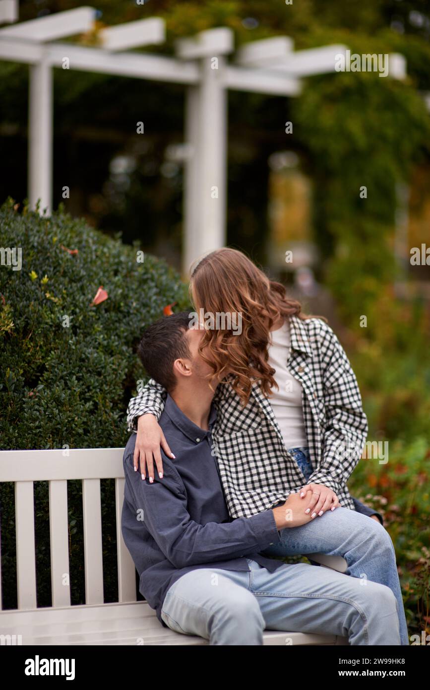 Autumn Romance: Young Couple Embracing and Kissing on Park Bench. Young ...
