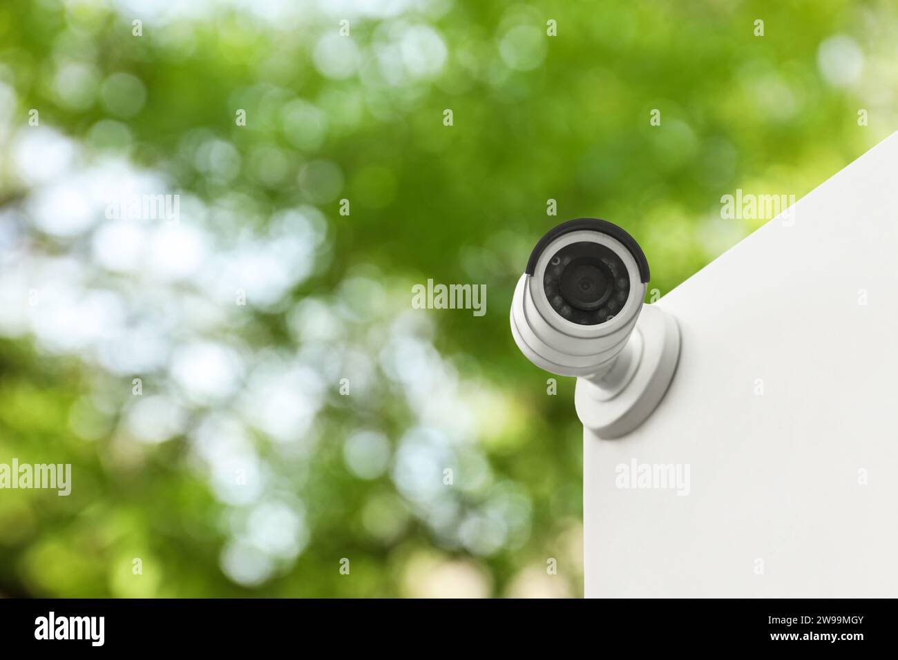Modern security CCTV camera on building wall outdoors, space for text ...