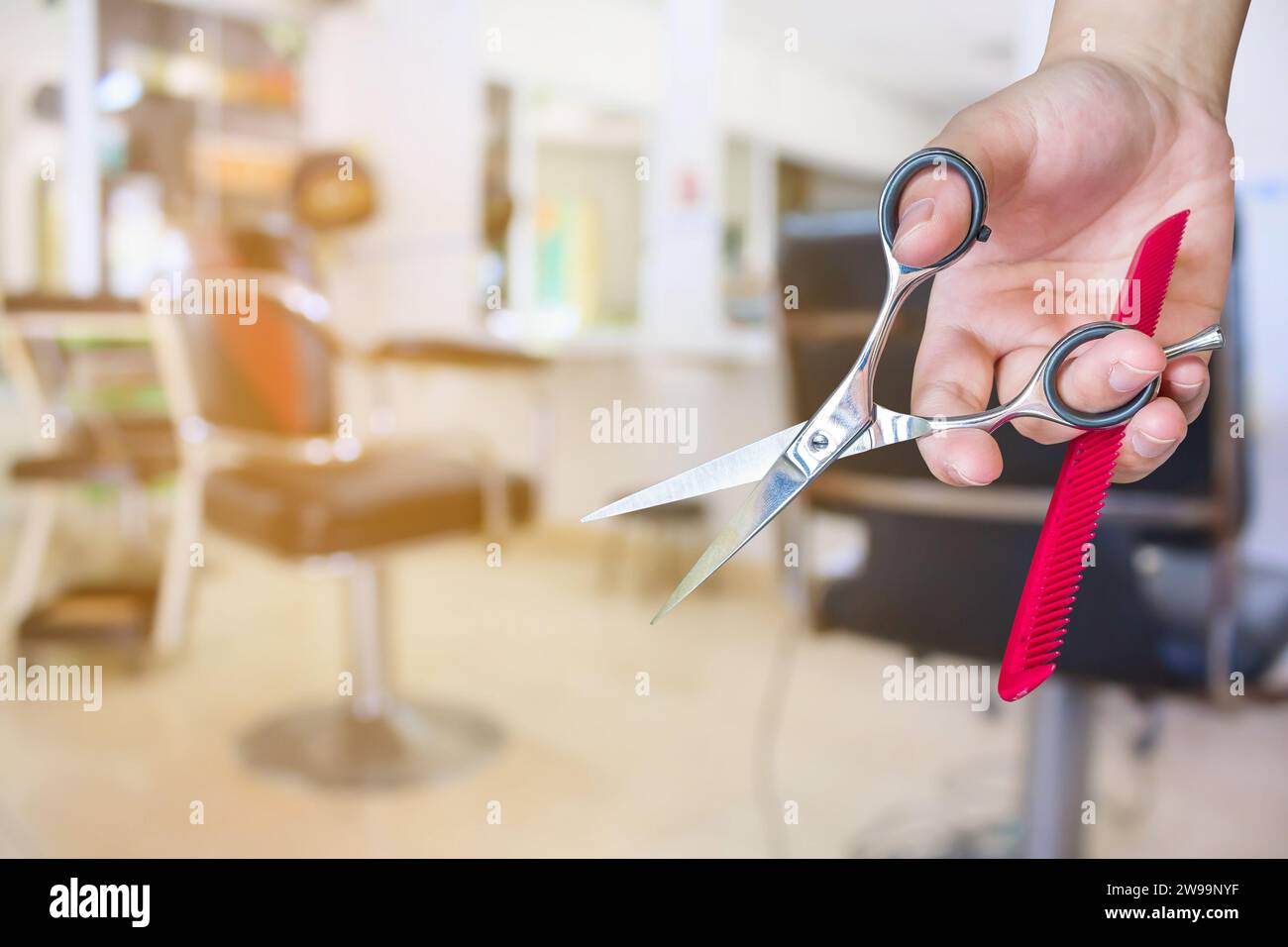 Hairdresser's hand hold scissors with salon beauty interior blur ...