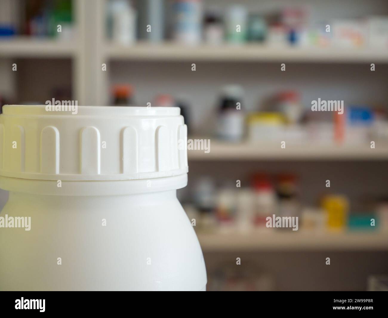 close up medicine bottle on counter with blur shelves of drug in the ...