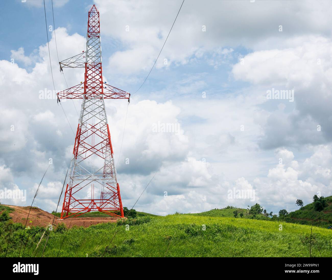 High voltage power lines tower on green mountain and sky with clouds ...