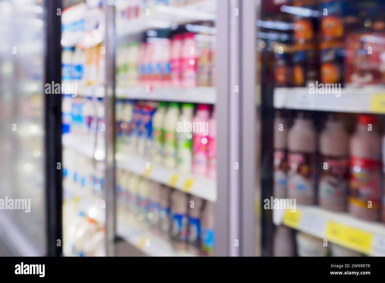 blur dairy product milk bottles on refrigerator shelf in supermarket ...