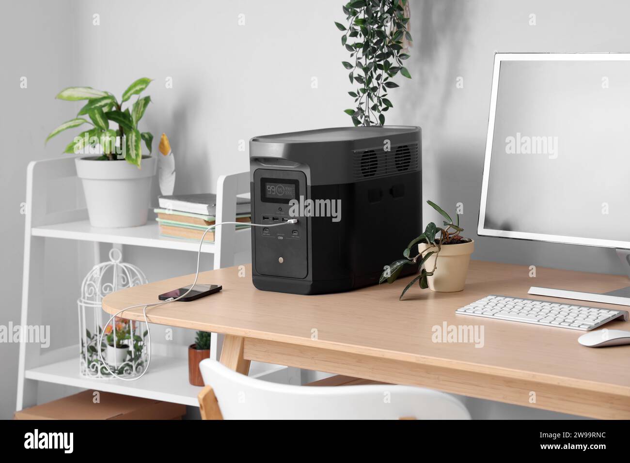 Comfortable workspace with modern computer and portable power station ...