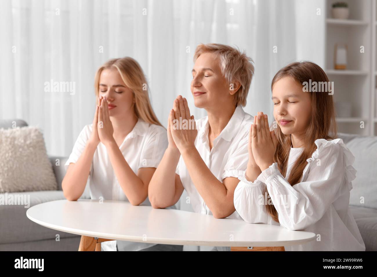 Little girl with her mom and grandmother praying at home Stock Photo ...