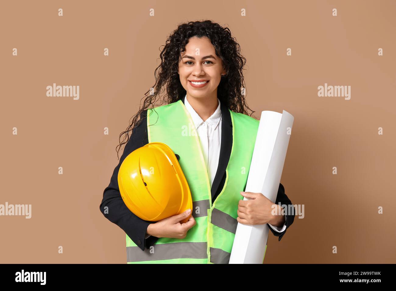 Beautiful young happy African-American female engineer with blueprint ...