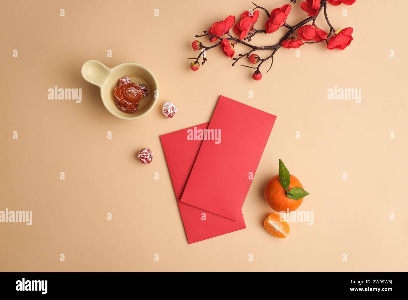 Two red envelopes, a tangerine, salted dried fruit and a peach blossom ...