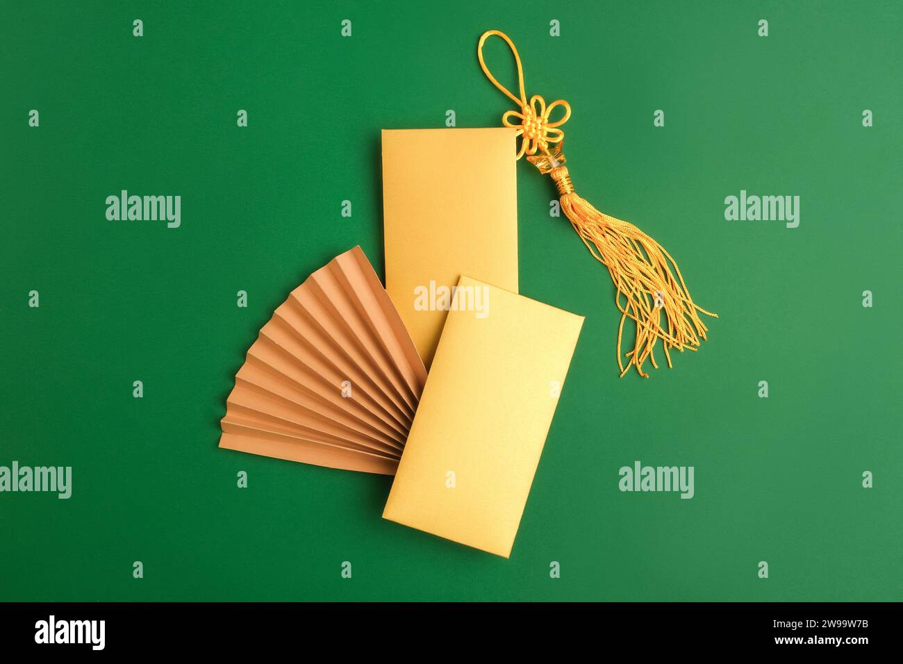 Two yellow lucky money envelopes, a paper fan and a decorative string ...