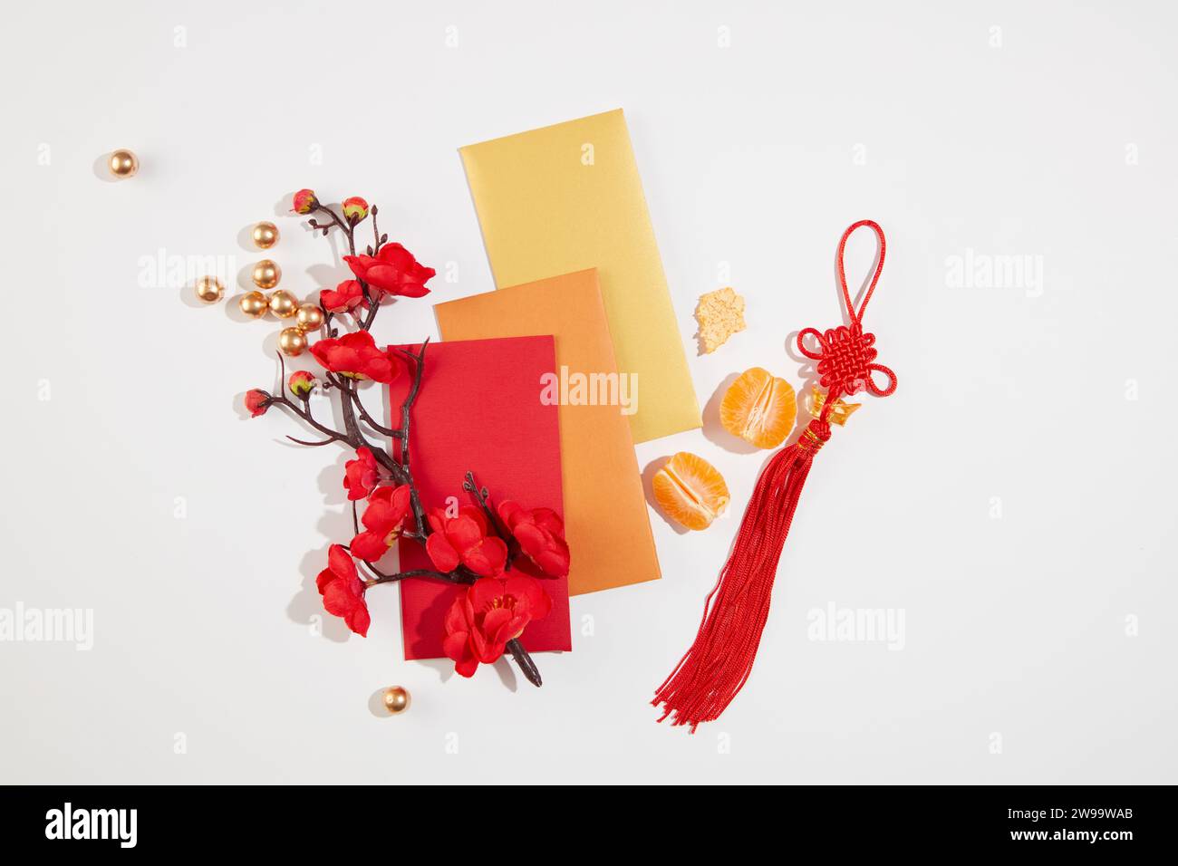 A peach blossom branch, red envelopes, tangerines and a decorative ...