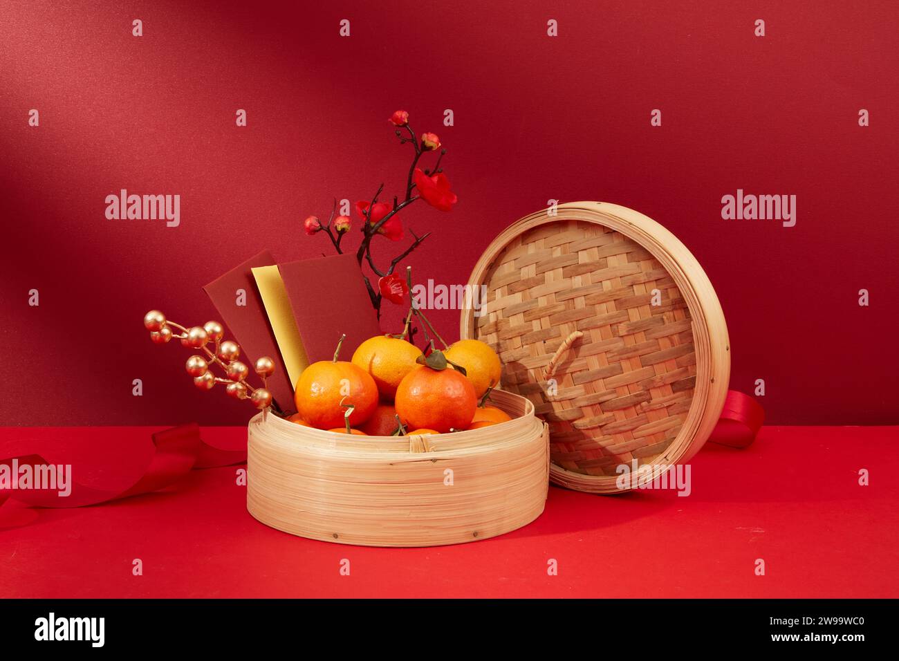 Tangerine inside a bamboo steamer, surrounded by decorative flower ...
