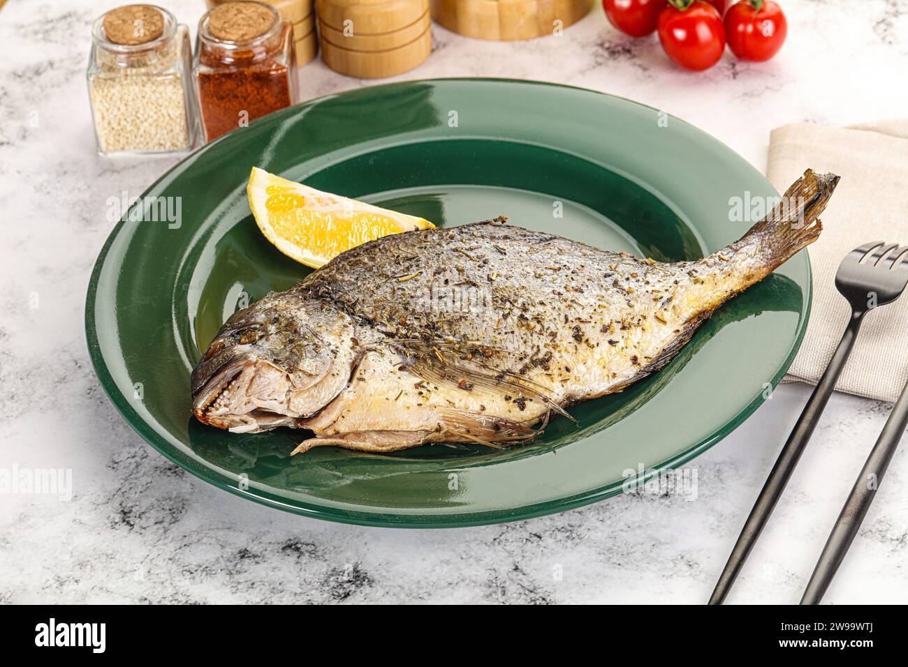 Baked Dorado fish served lemon slice Stock Photo - Alamy