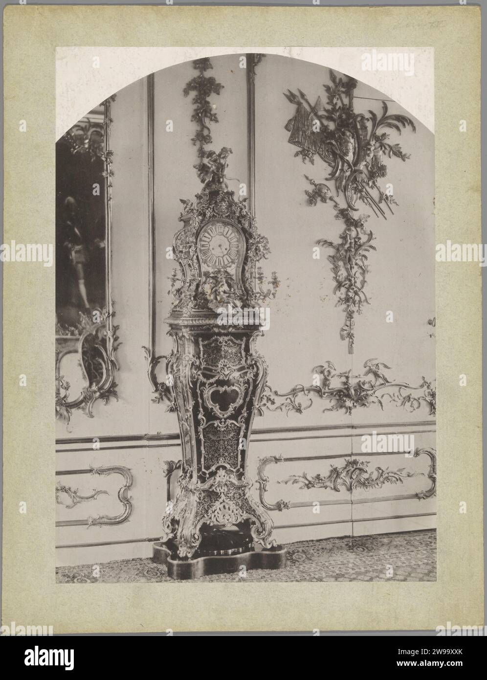 Standing clock decorated with plant motifs, a putti and a goddess ...