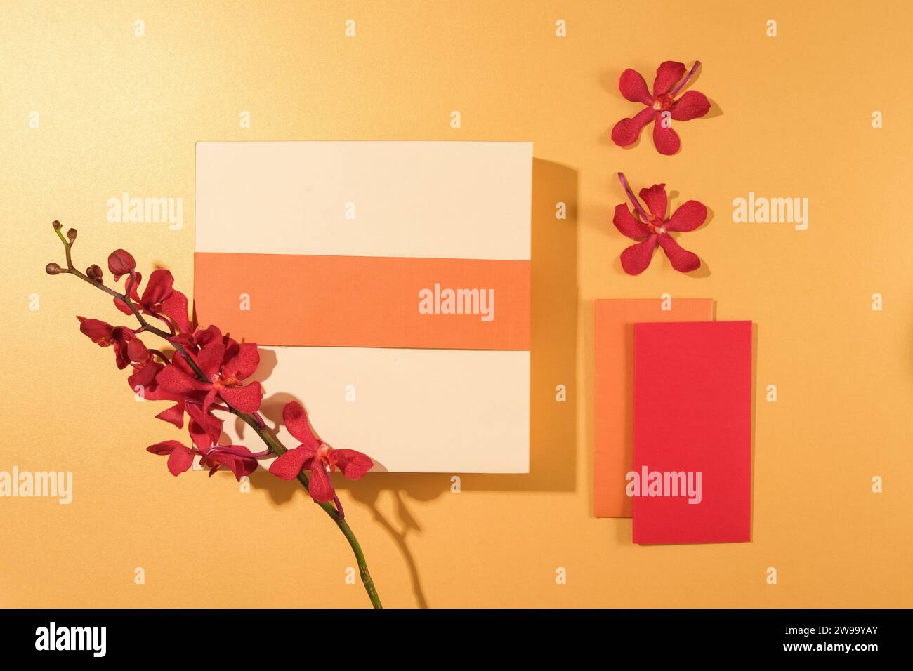 A stylish gift box, lucky money envelopes, and red orchid branches on ...