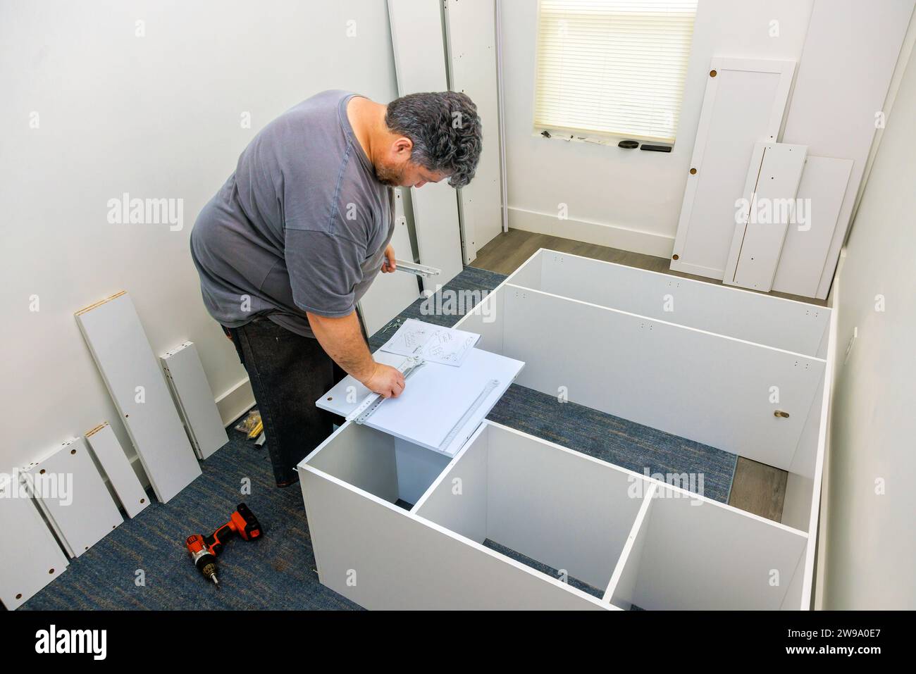 At time of assembling furniture closet cabinets to rooms carpenter is ...