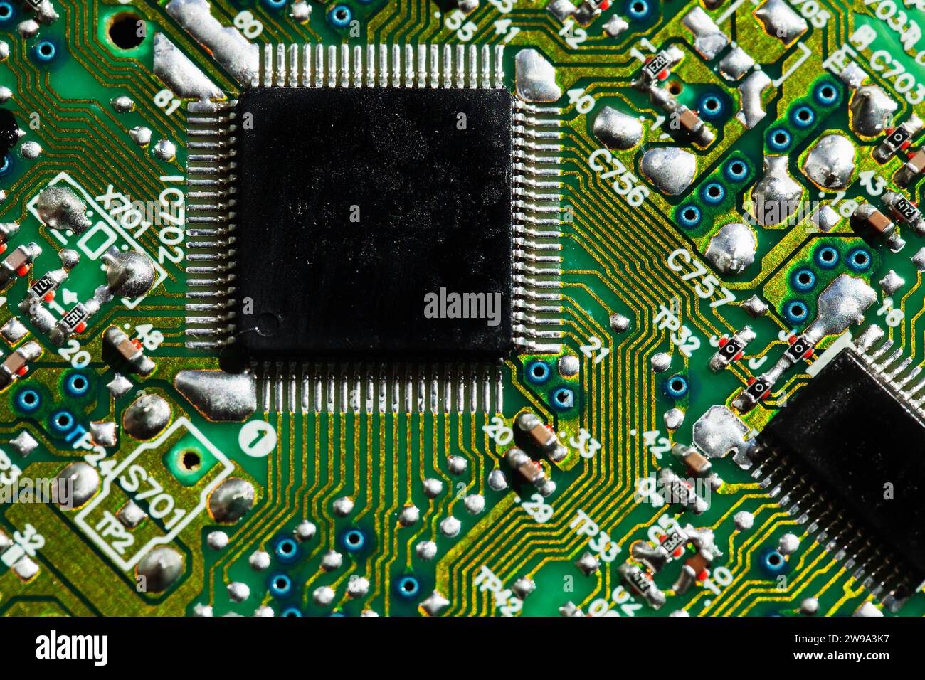 Microchip and capacitors, green printed circuit board top view, close ...