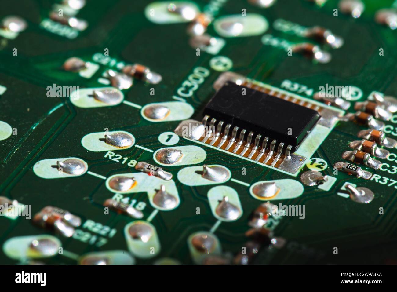 Micro chip and capacitors mounted on a green printed circuit board ...