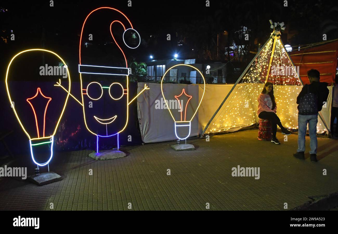 Mumbai, India. 25th Dec, 2023. A woman takes a photo near a light ...