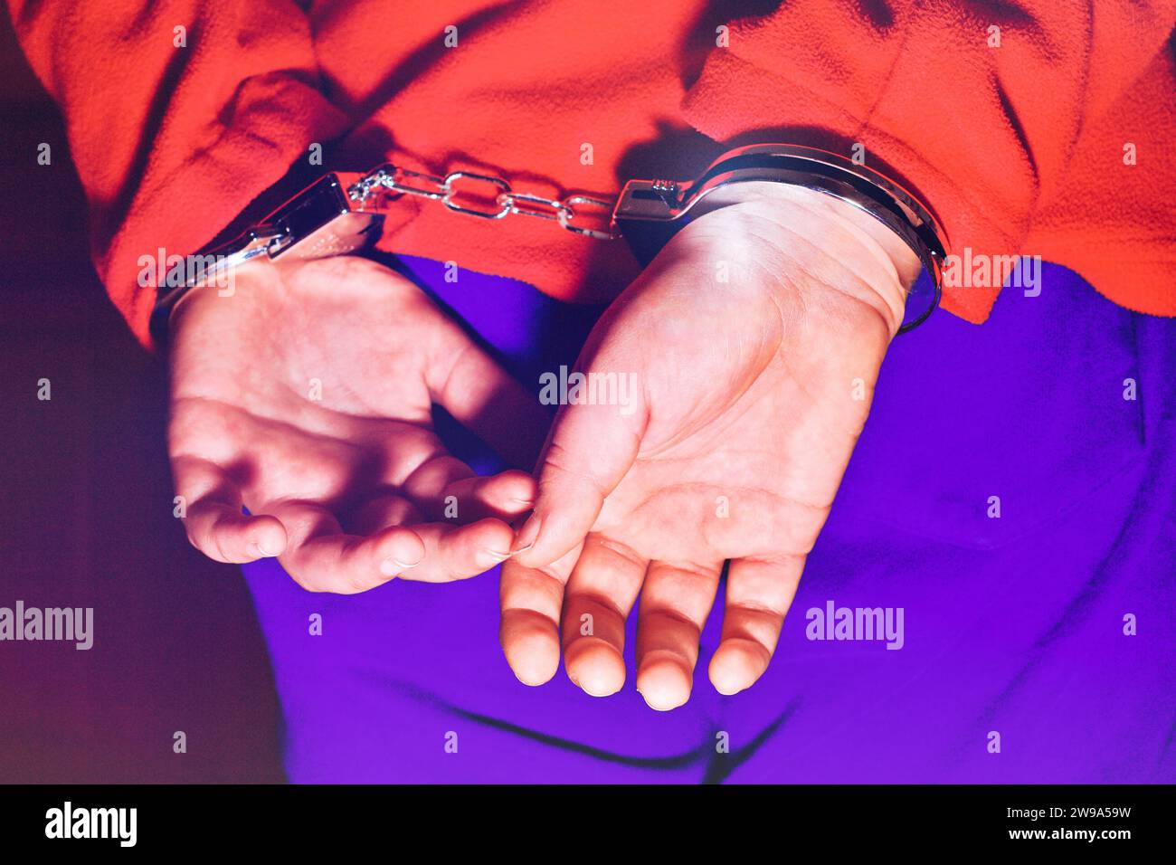 Arrested man in handcuffs with handcuffed hands behind back in prison ...