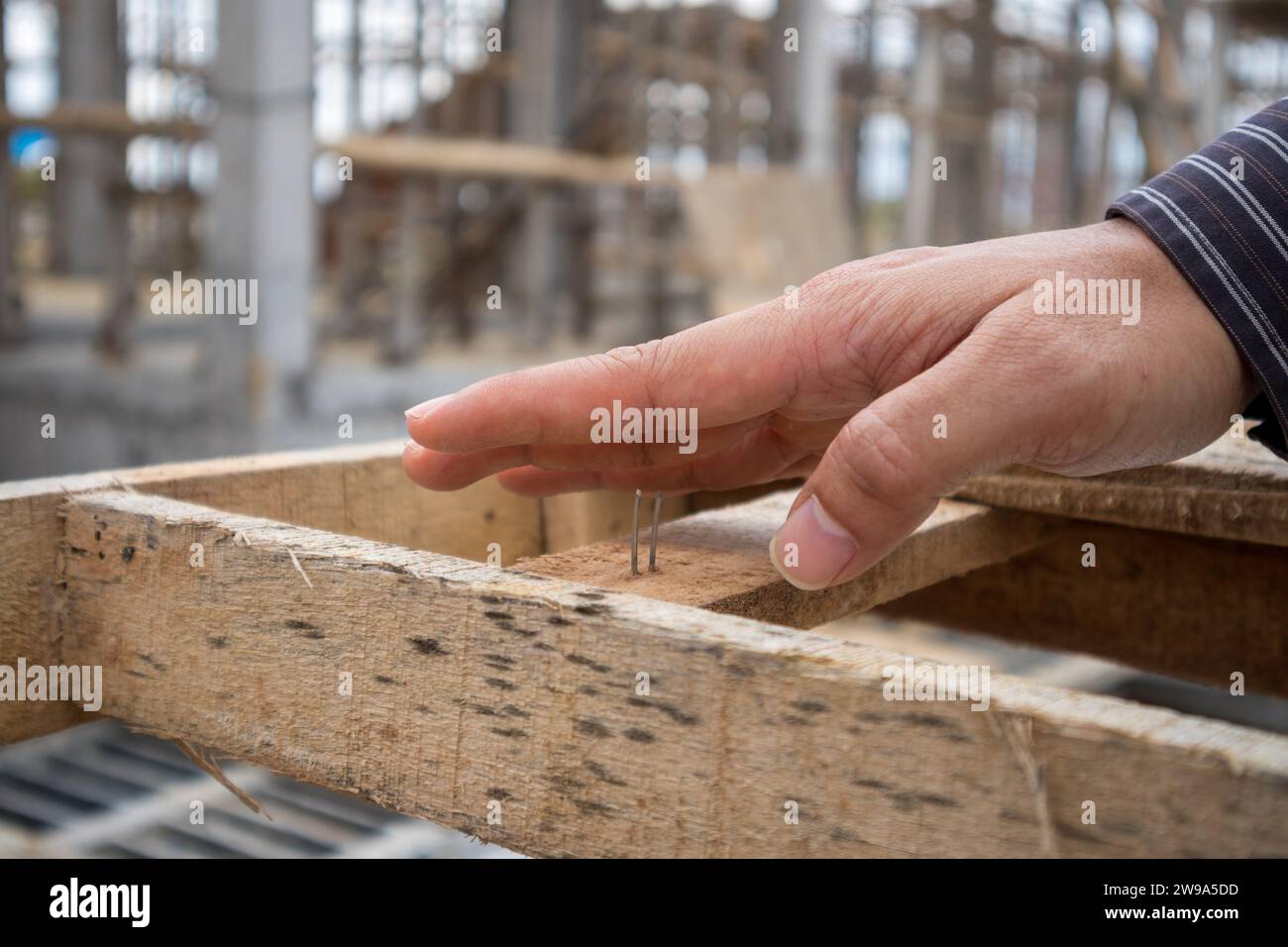 Construction worker hand on nail at house building site, work accident ...