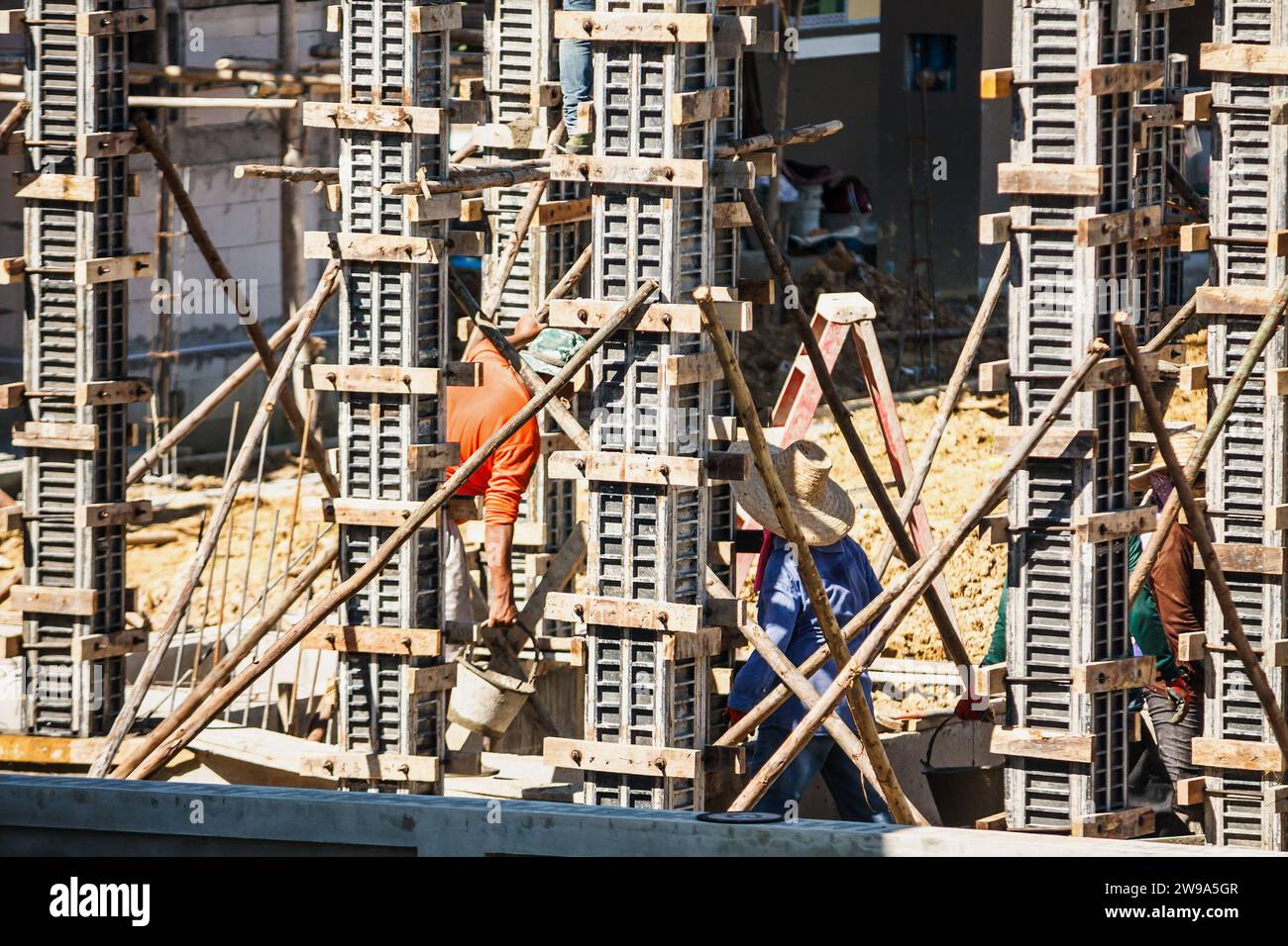 Worker pouring concrete to formwork frames at construction site to ...