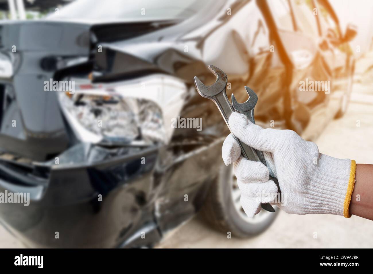Hand hold wrench with car crash damaged background Stock Photo - Alamy