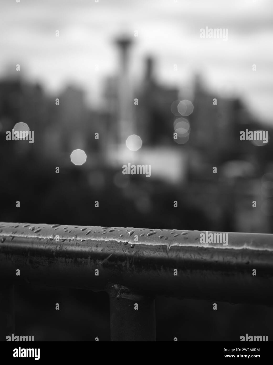 A vertical of a railing in raindrops against the cityscape of Seattle ...