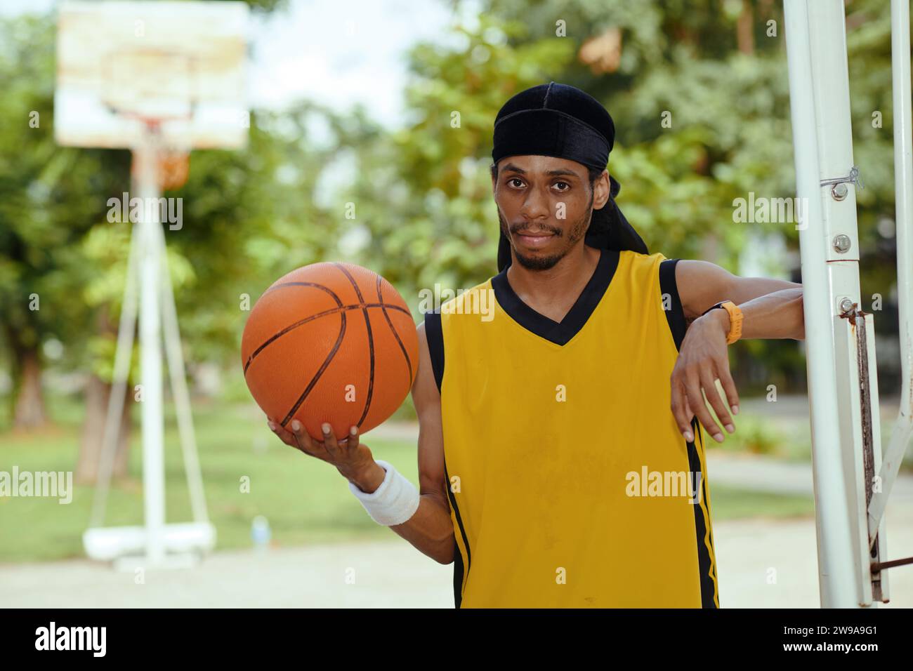 Portrait of basketball player with durag on head training outdoors ...