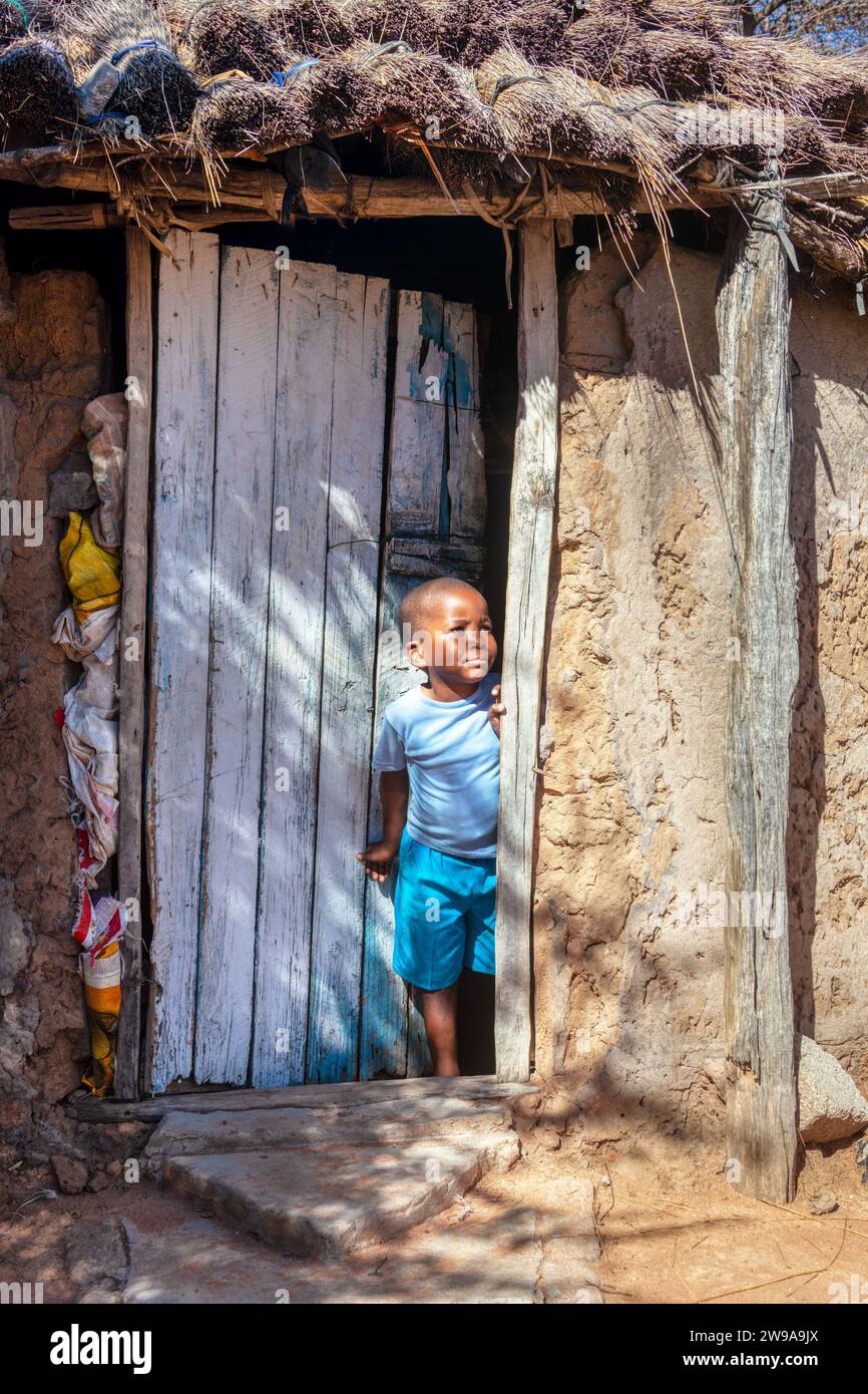 african kid in front of a hut with a thatched roof in the slum Stock ...