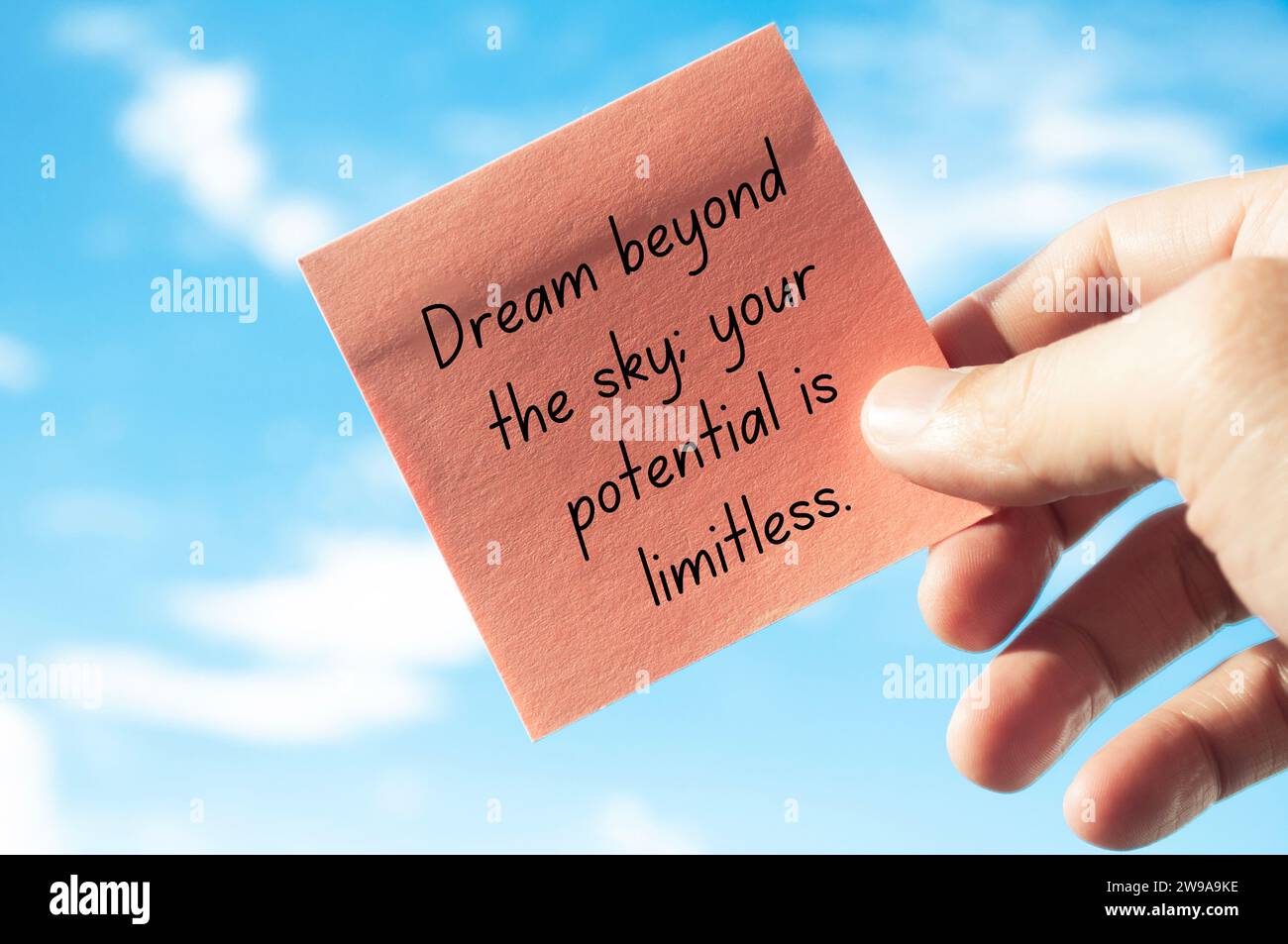 Motivational quote about dreaming beyond the sky on sticky note with ...