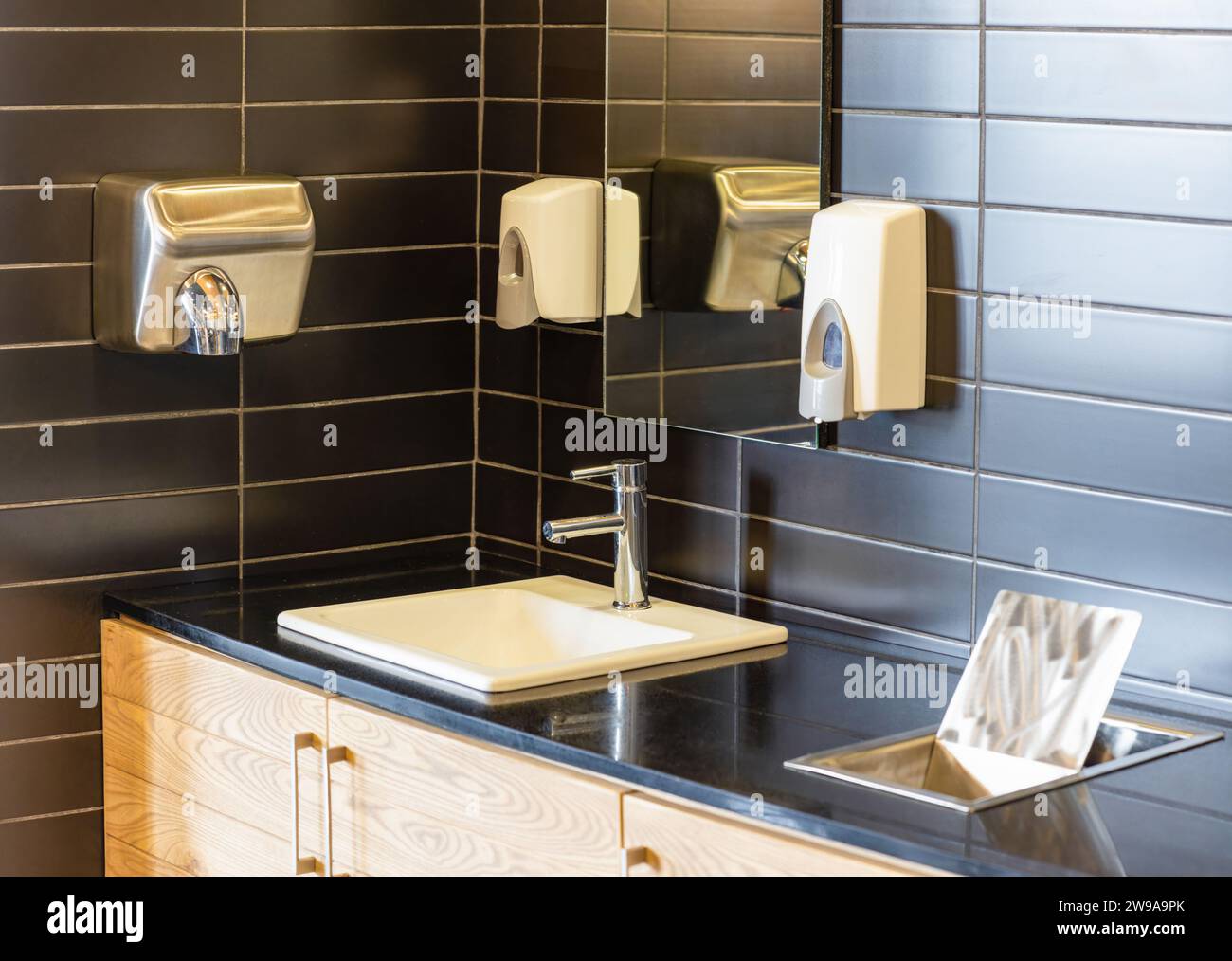 designer washing sink with hand dryer and soap dispenser in a ...