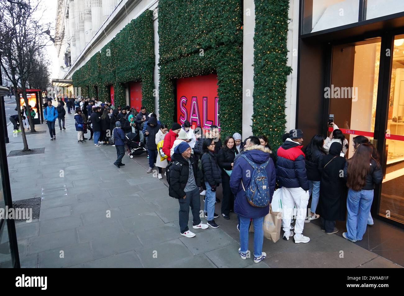 A small line of shoppers queueing outside Selfridges department store on London's Oxford Street ...