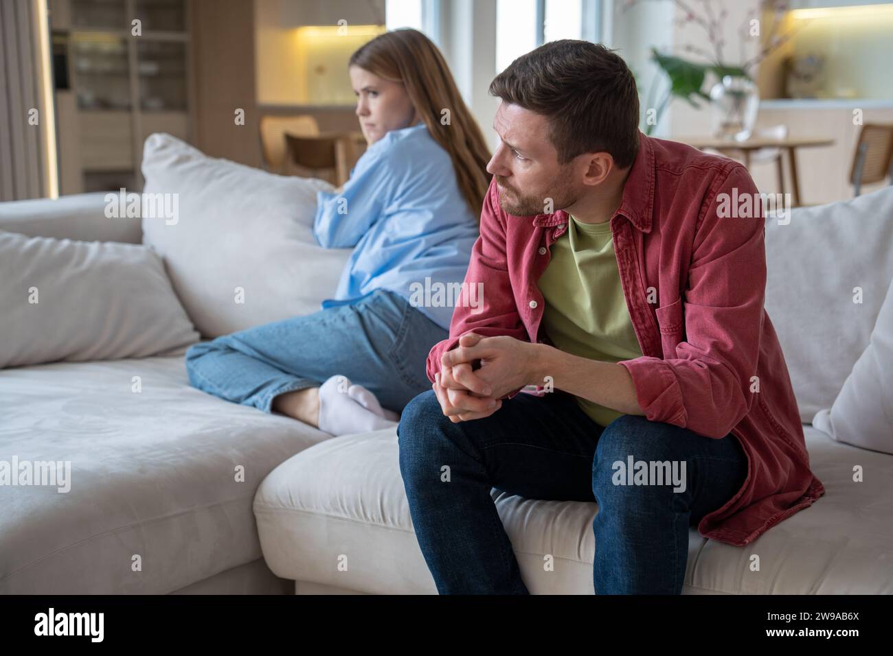 Couple man woman ignoring each other sitting on couch in silence at ...