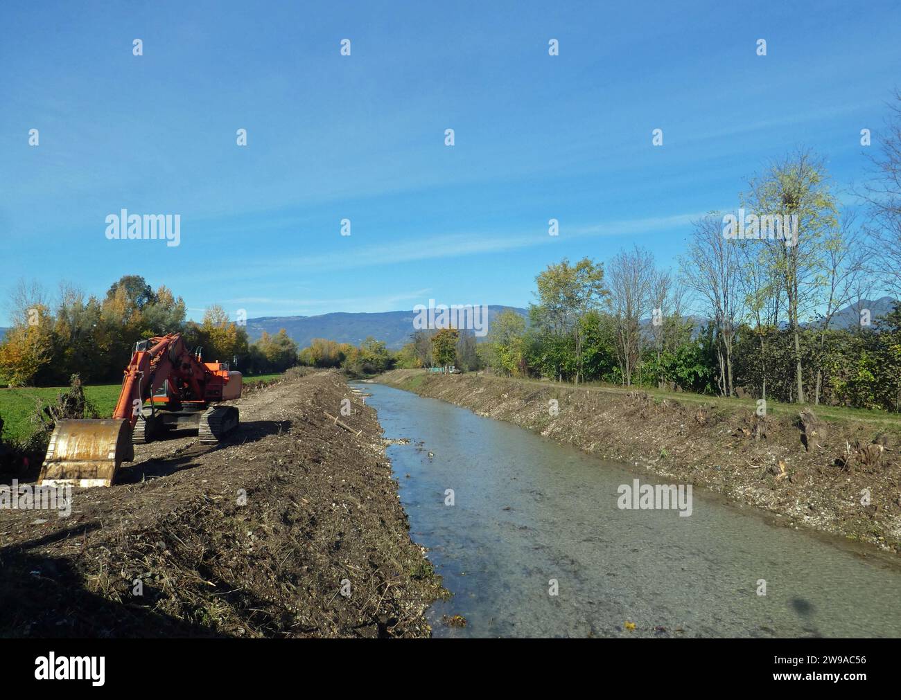 big digger on the river bank during maintenance work on the embankment ...
