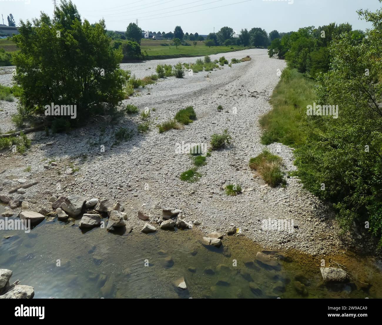 wide river bed with little water due to the summer drought without ...