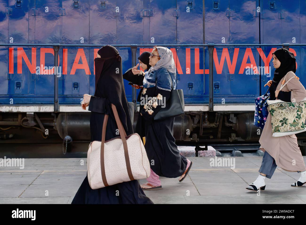 Muslim women in traditional Muslim clothing, rail passengers, pass an ...
