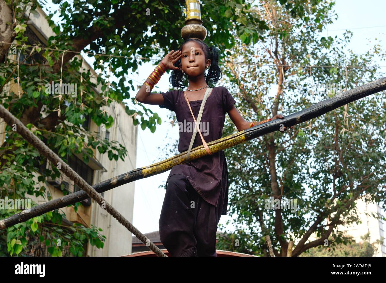 In a street performance or tamasha, a young Indian girl walks a ...
