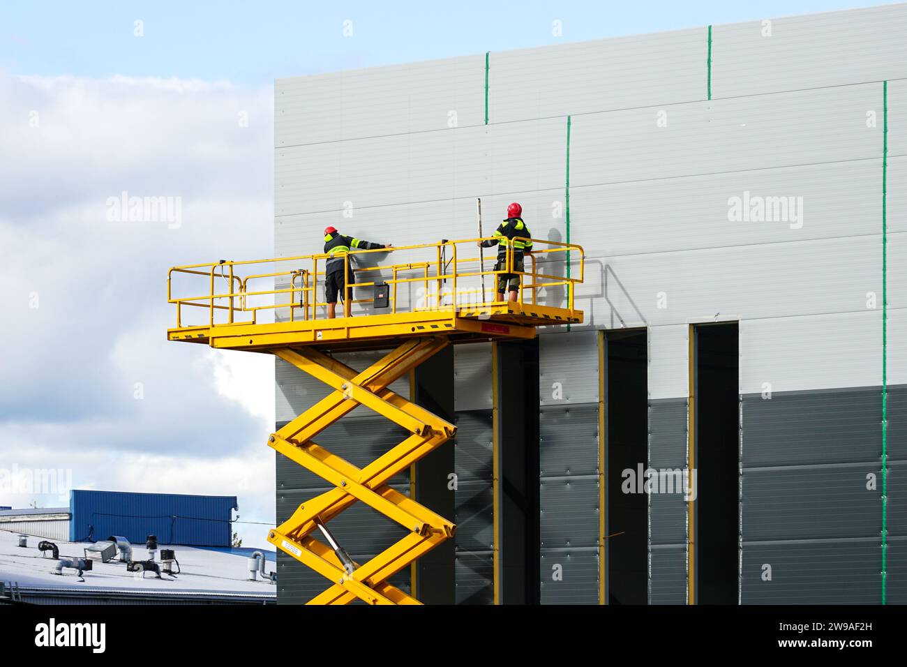 Large elevated aerial scissor lift working platform with workers ...