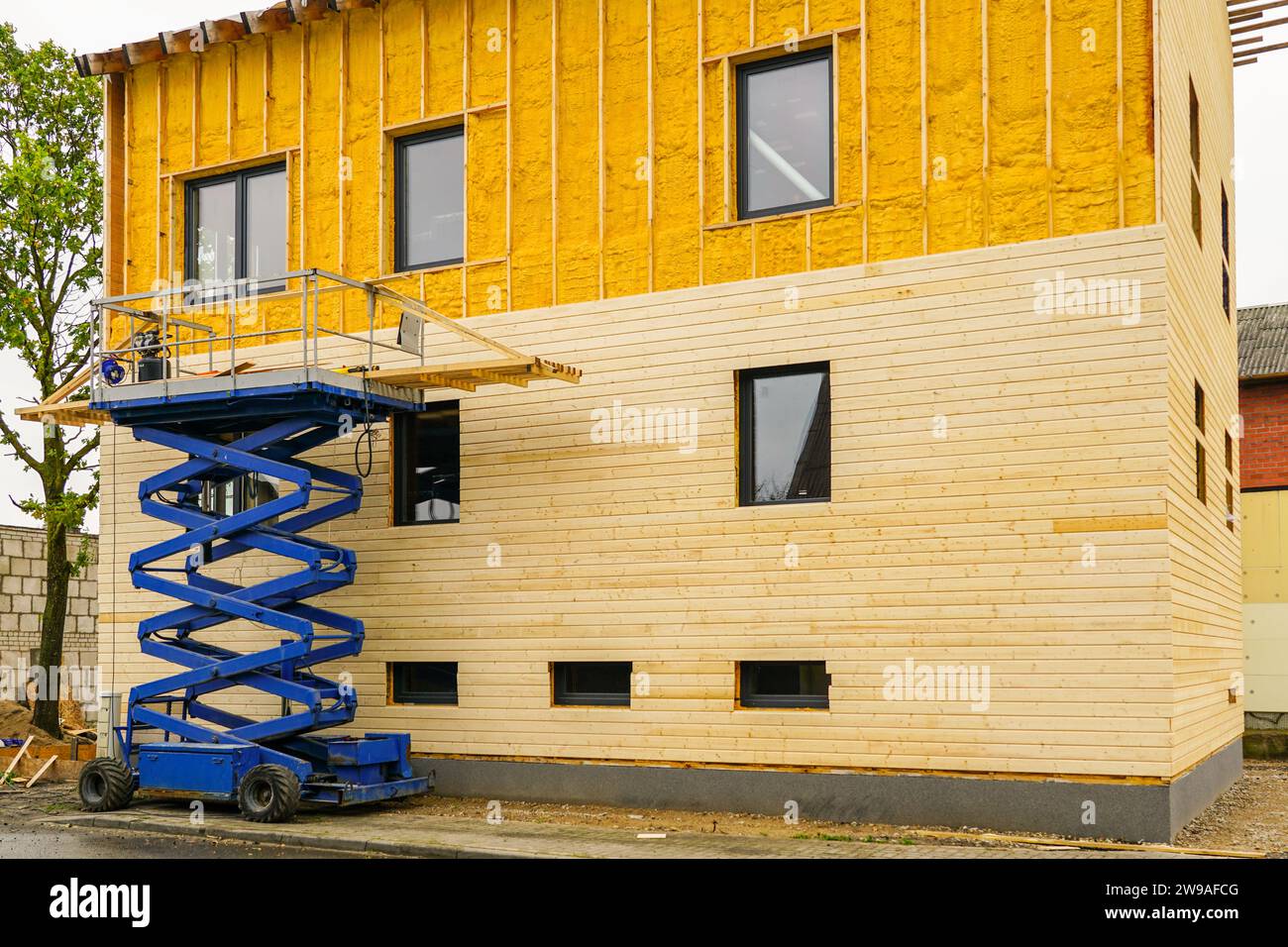 Using a scissor lift in facade cladding works after spraying the facade ...