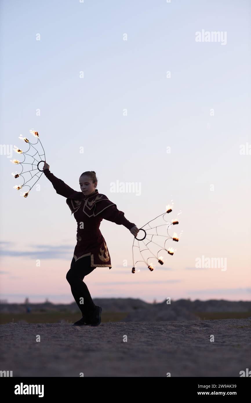 Vertical full length portrait of young woman as fire show performer ...
