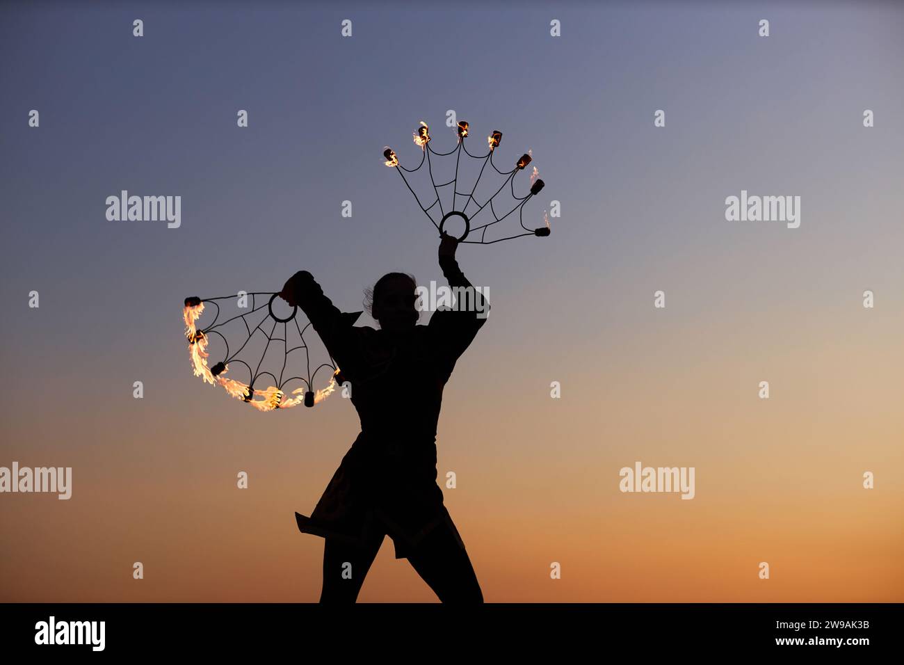 Black outline of female fire show performer dancing with flaming fans ...