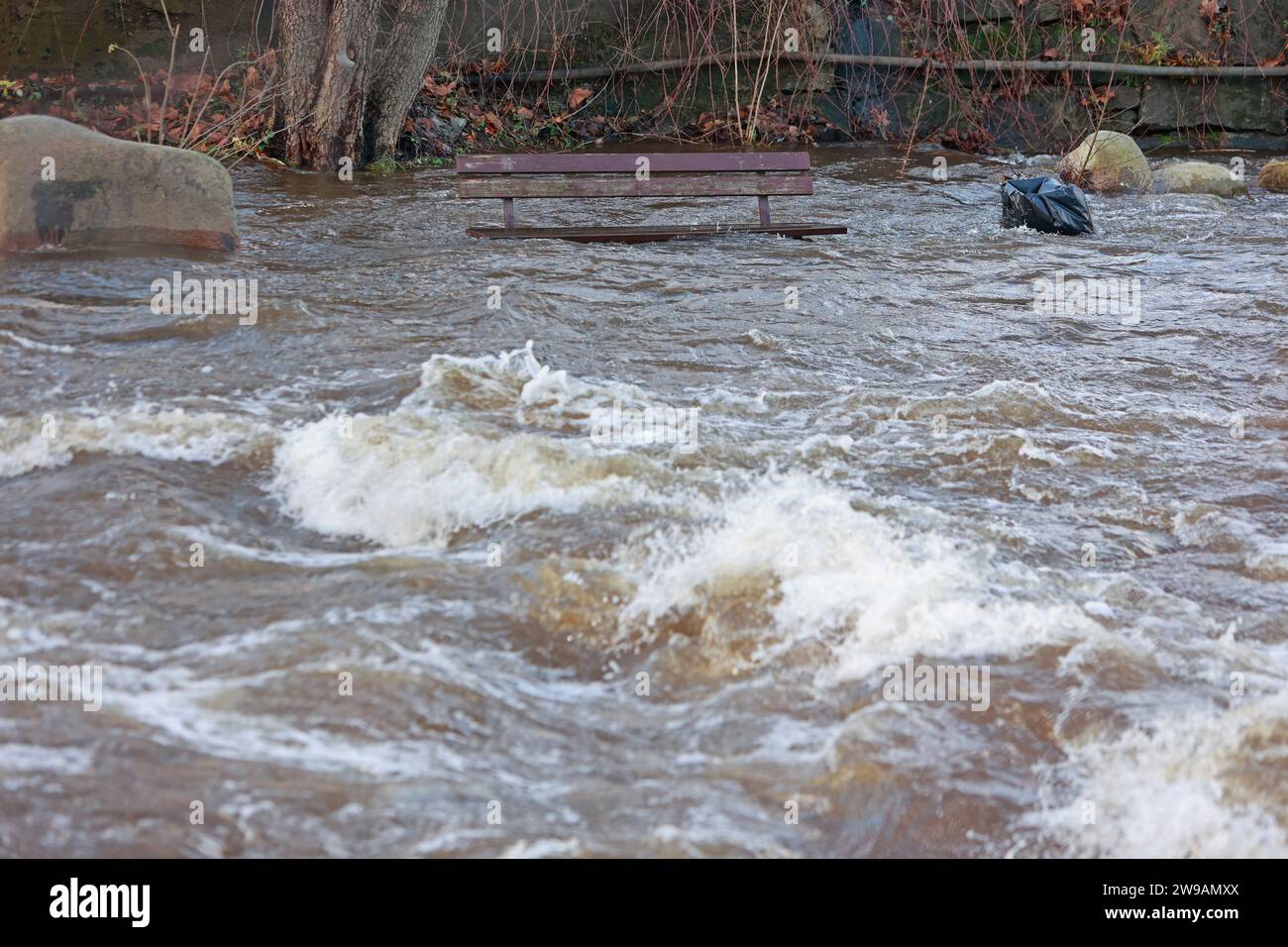 Oker, Germany. 26th Dec, 2023. Benches stand in the floodwaters of the ...