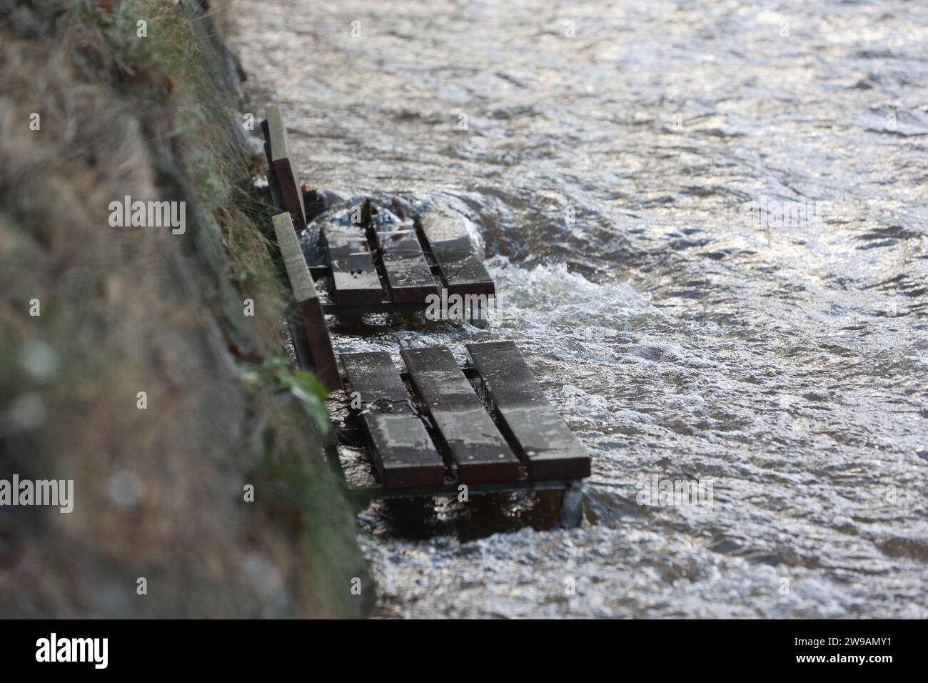 Oker, Germany. 26th Dec, 2023. Benches stand in the floodwaters of the ...