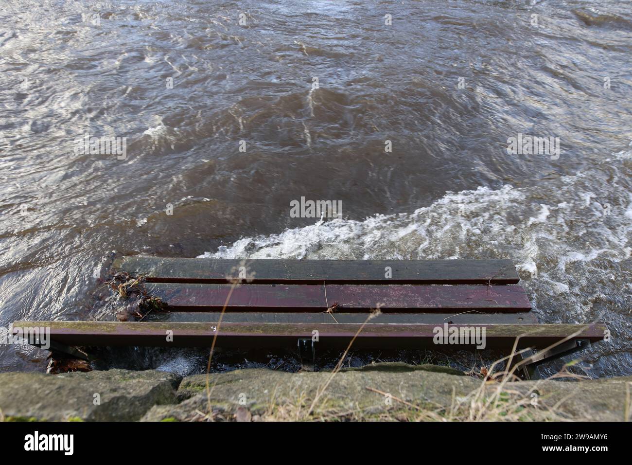 Oker, Germany. 26th Dec, 2023. Benches stand in the floodwaters of the ...