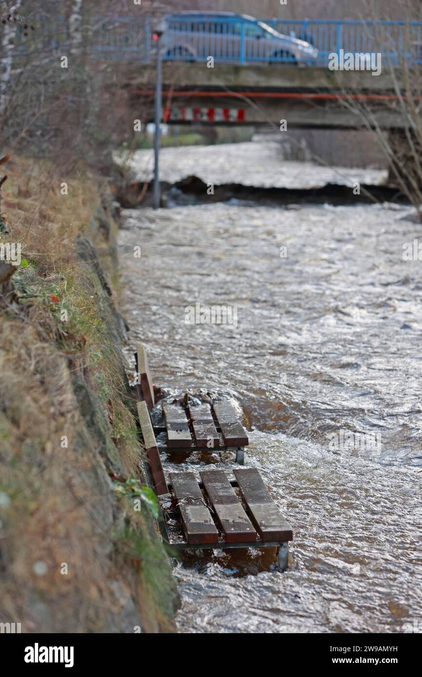 Oker, Germany. 26th Dec, 2023. Benches stand in the floodwaters of the ...