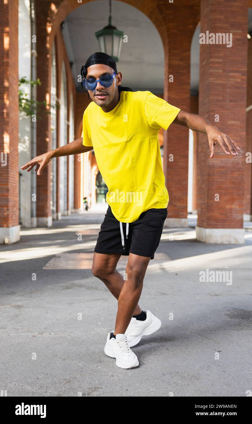 Black urban young man dancing a modern dance in the street enjoying the ...