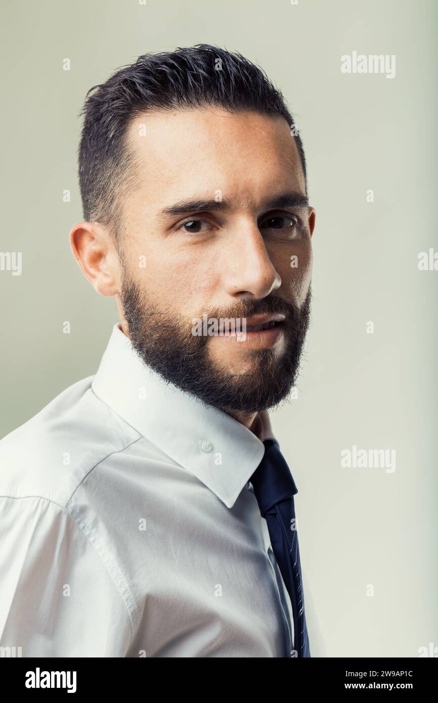 Confident businessman with a well-groomed beard poses in semi-profile ...