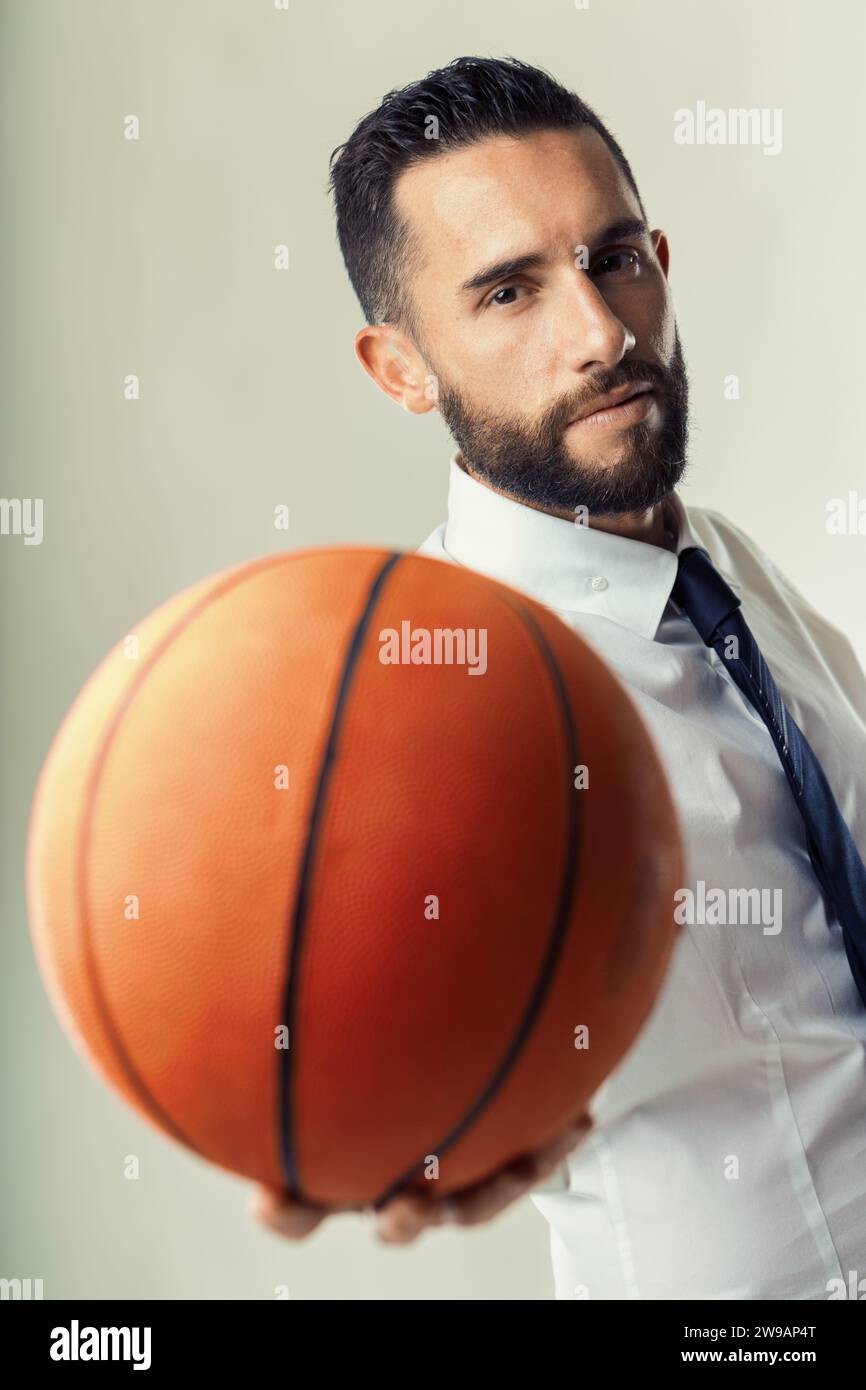 Businessman with a basketball demonstrates the balance of strategic ...